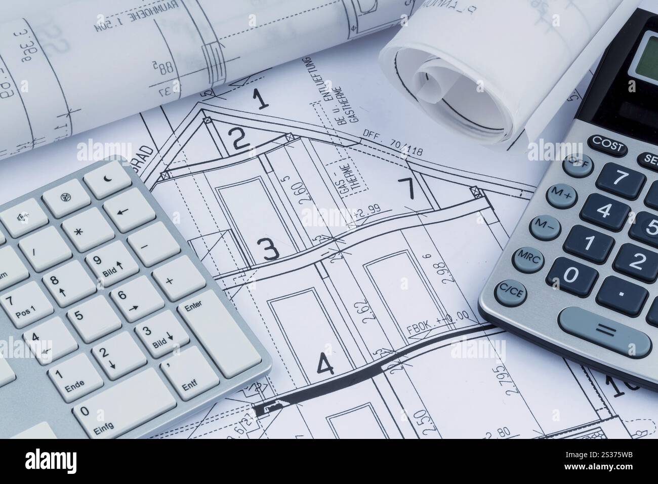 An architect's construction plan with a calculator. Symbolic photo for ...