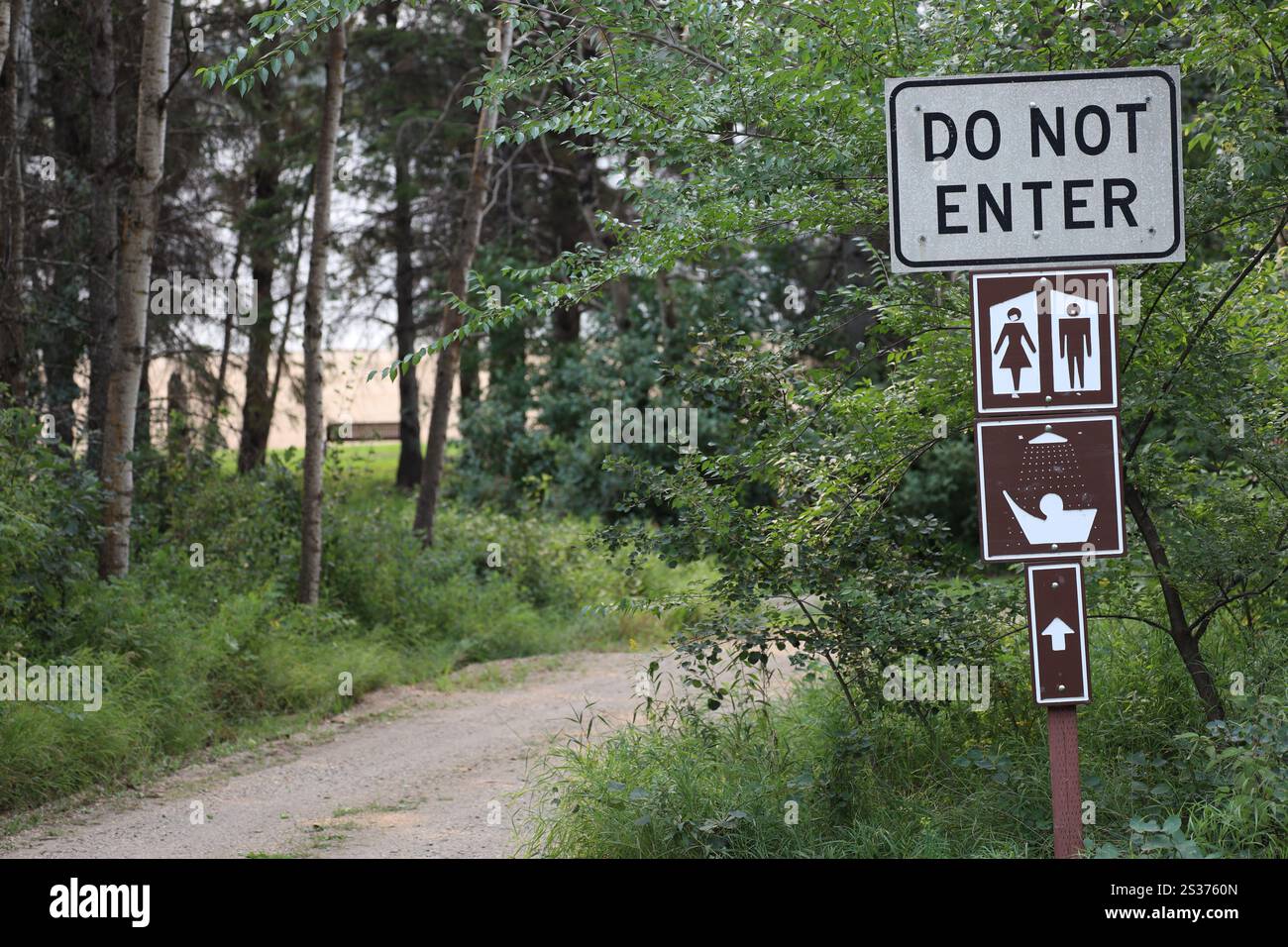 confusing sign beside rural gravel road in trees Stock Photo - Alamy
