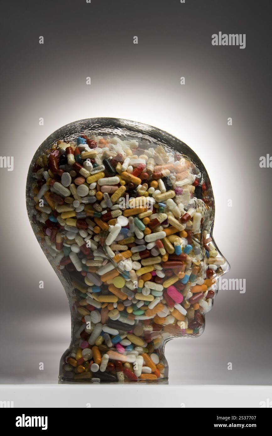Tablets in glass head Stock Photo - Alamy