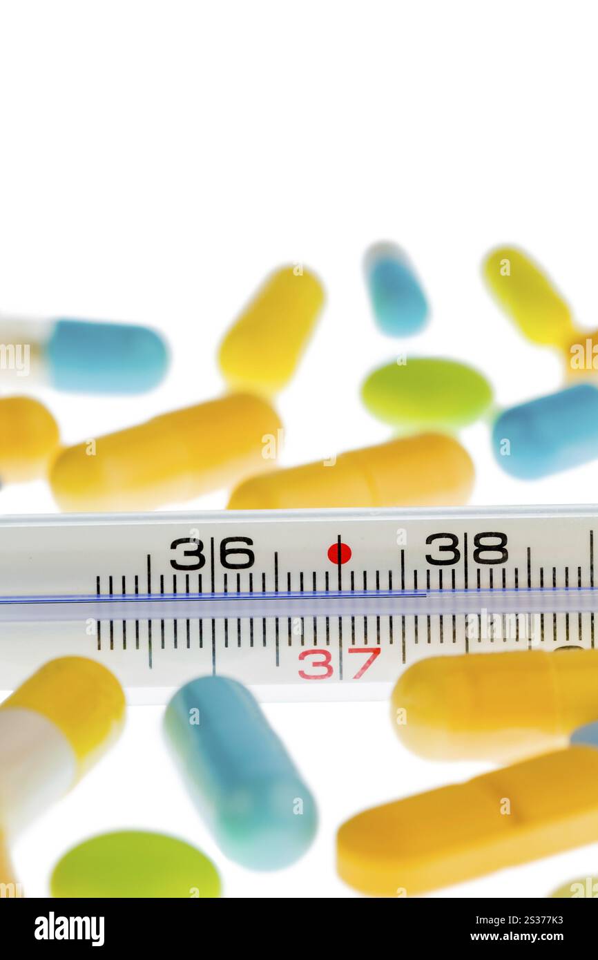 A clinical thermometer and tablets. Symbol photo for flu and colds ...