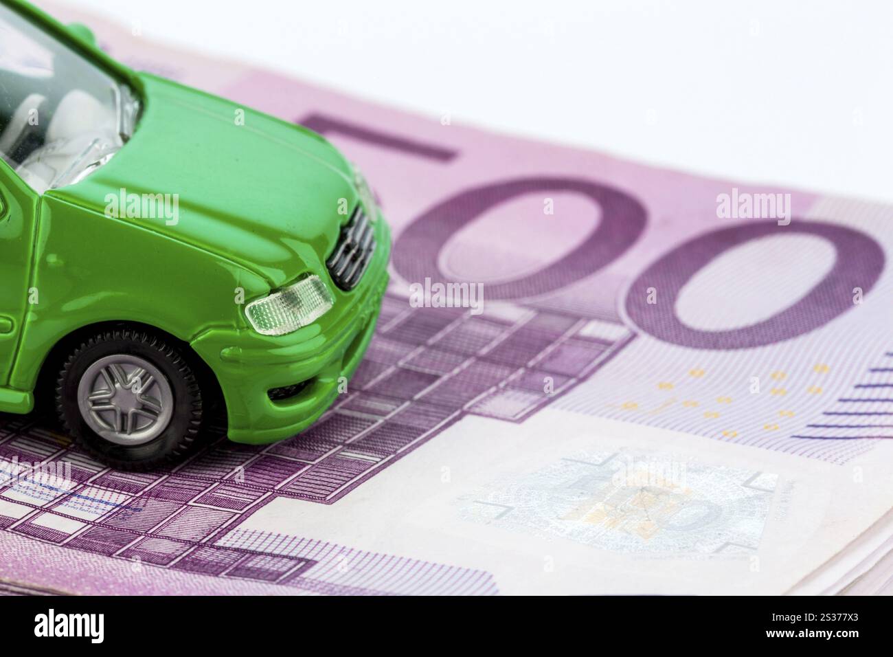 Green model car on banknotes, symbolic photo for car purchase ...