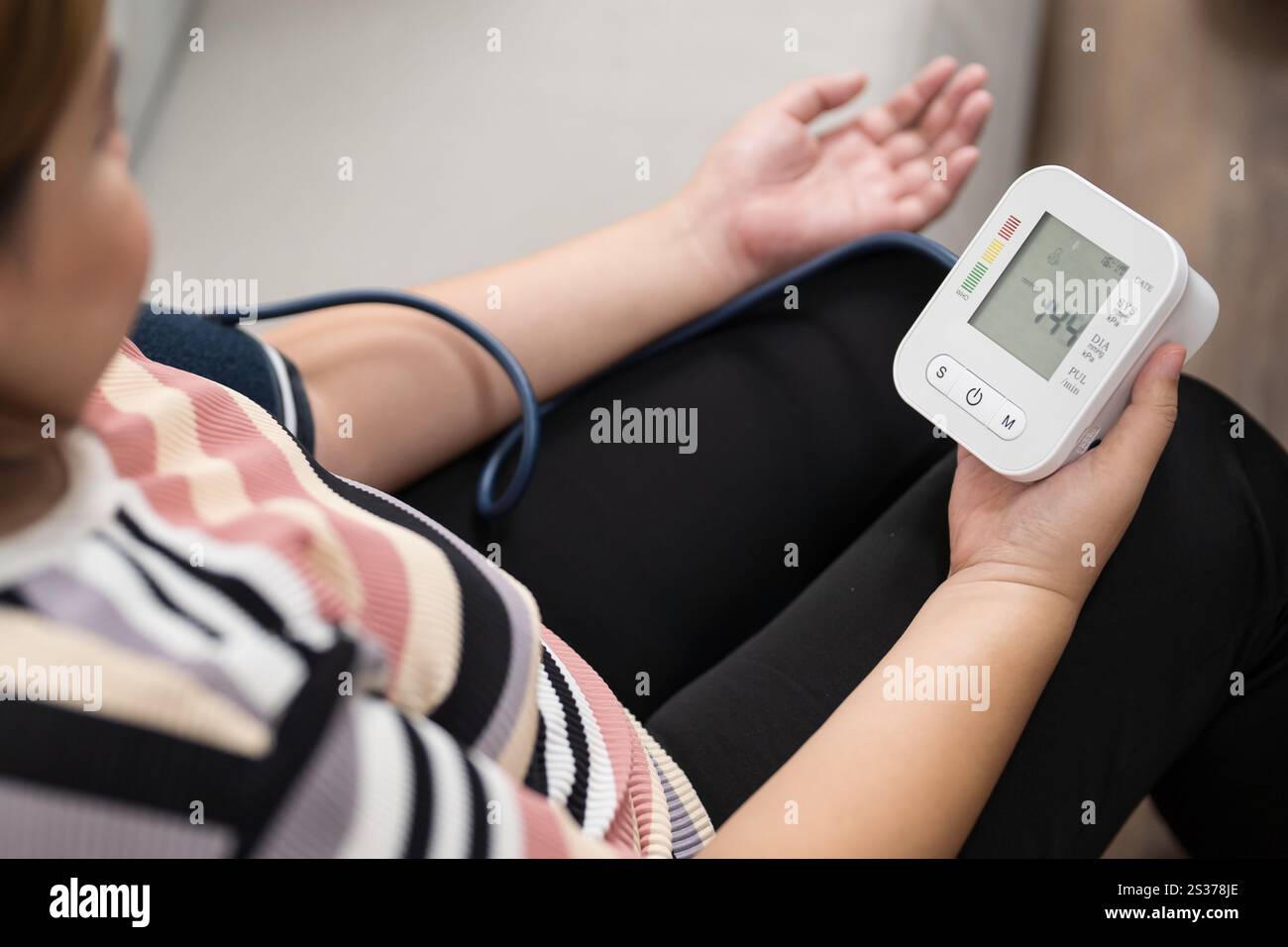 woman Overweight plus size self checks measuring blood pressure and ...