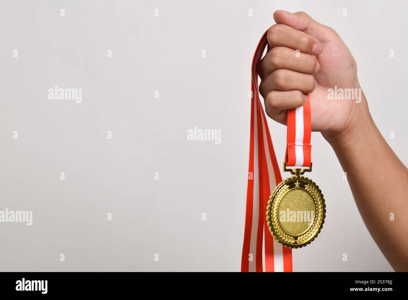 Hand holding gold medal isolated on white background. The winner and ...