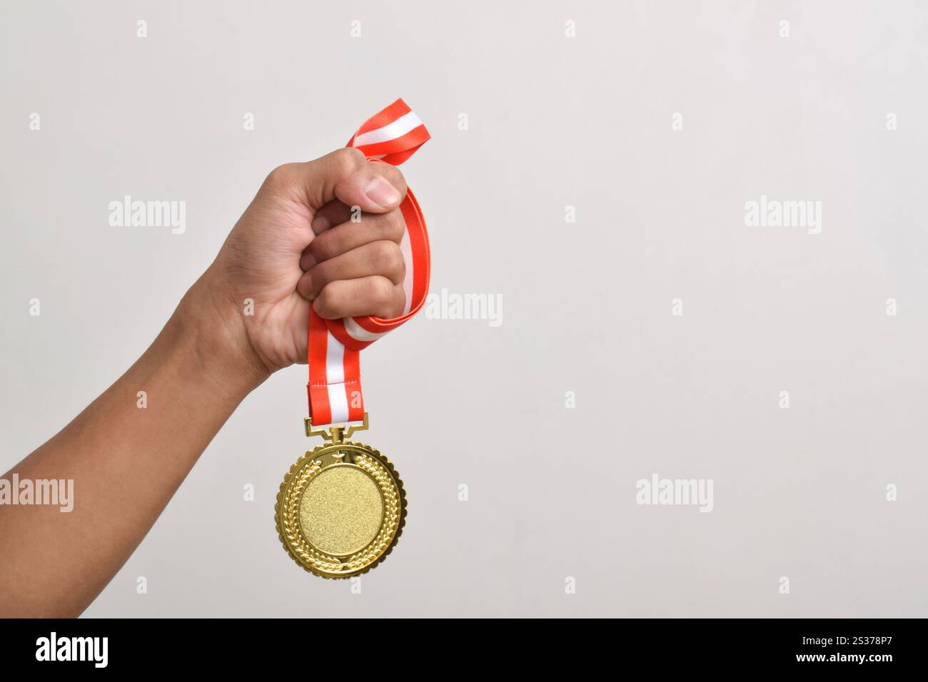 Hand holding gold medal isolated on white background. The winner and ...