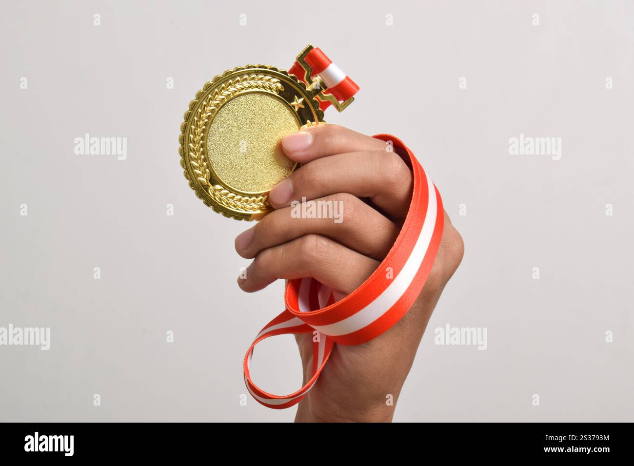 Hand holding gold medal isolated on white background. The winner and ...