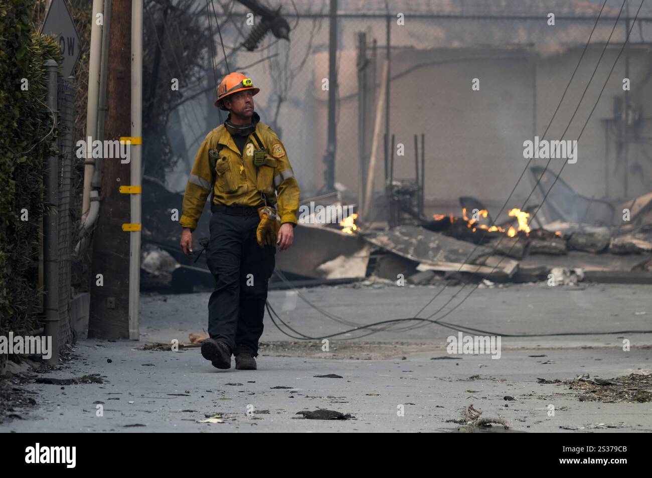 A Los Angeles County Fire Dept. fire fighter walks in the Altadena ...