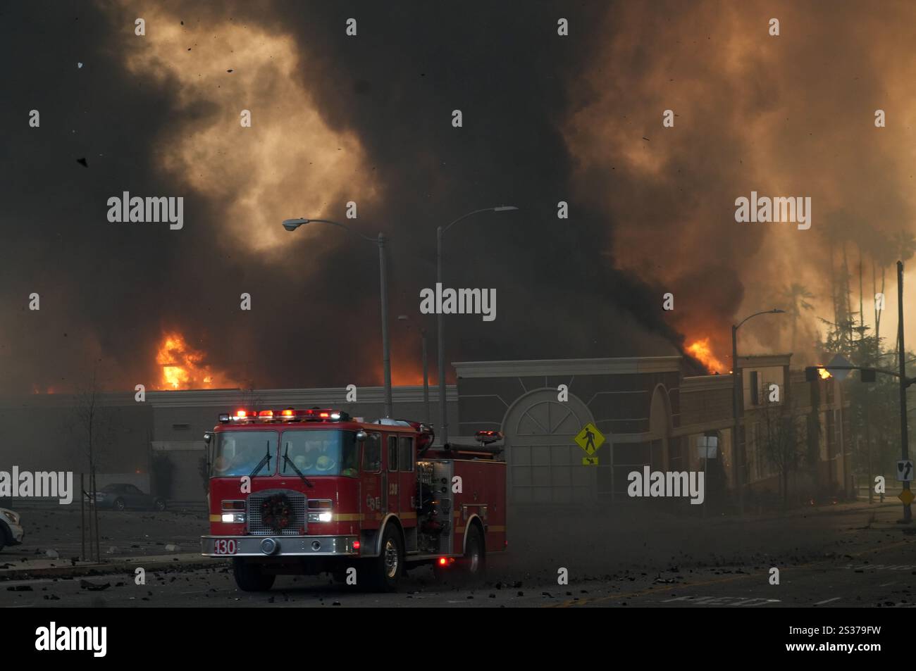 A Los Angeles County Fire Dept. truck drives by a burning Aldi USA ...