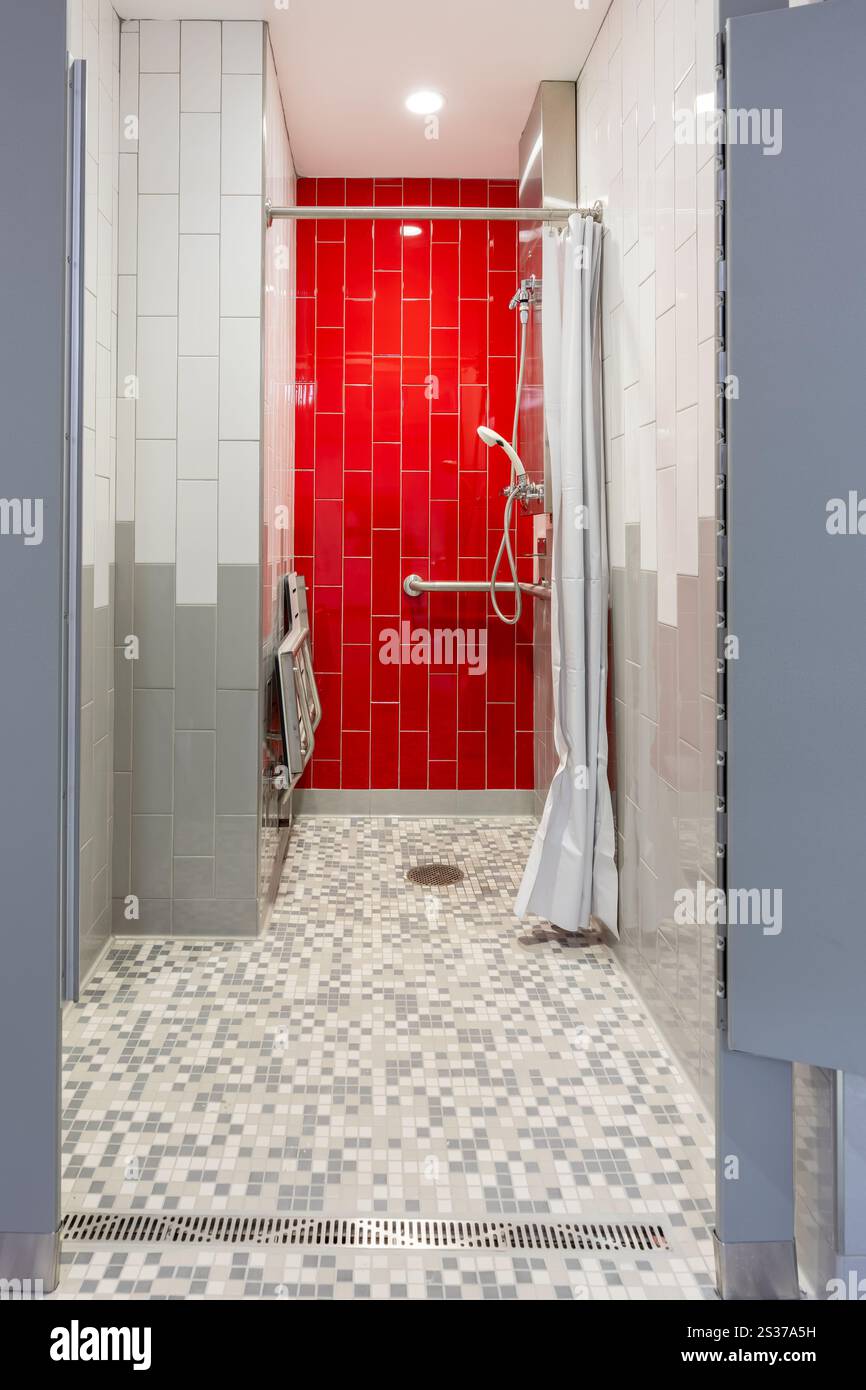 Vertical photo of a new single, private, gym locker room shower with ...