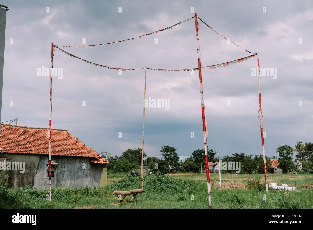 An open field with four bamboo poles and ropes in the center, set up as ...