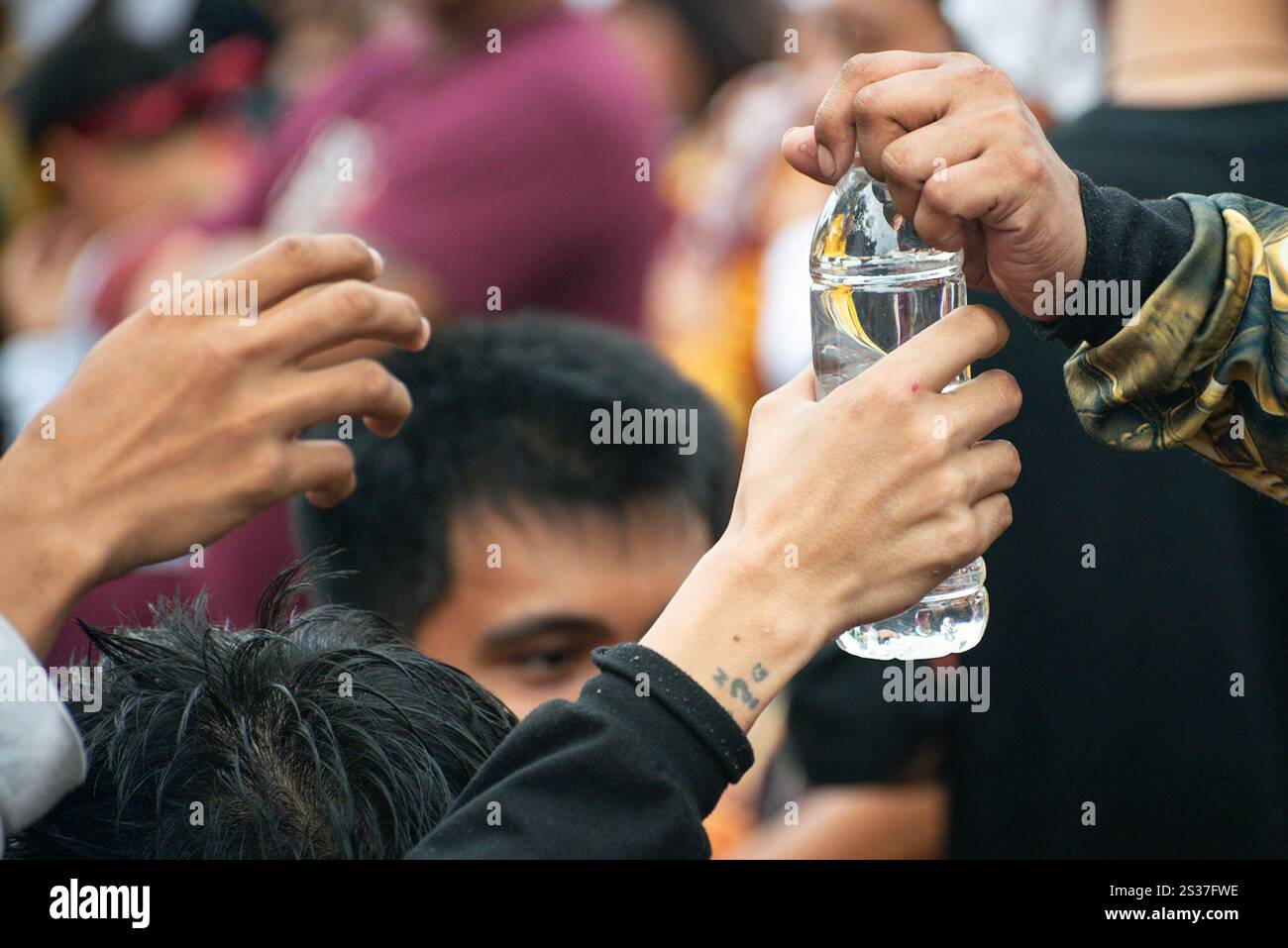 January 9, 2025, Manila, Ncr, Philippines: A volunteer passes water to ...