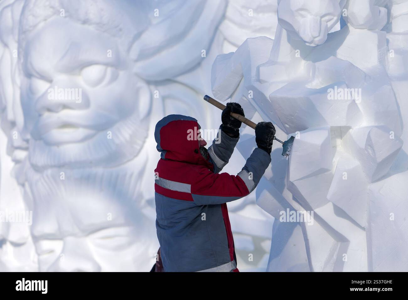 An artist works on a snow sculpture during the Harbin International ...