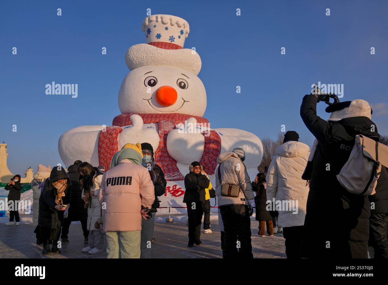 Visitors gather to take picture of a giant snowman on display at the ...