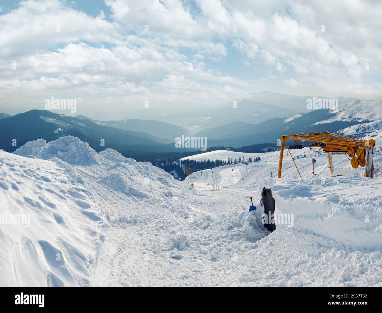 Snow-covered ski hoist ropeway (upper terminal) and mountain landscape ...