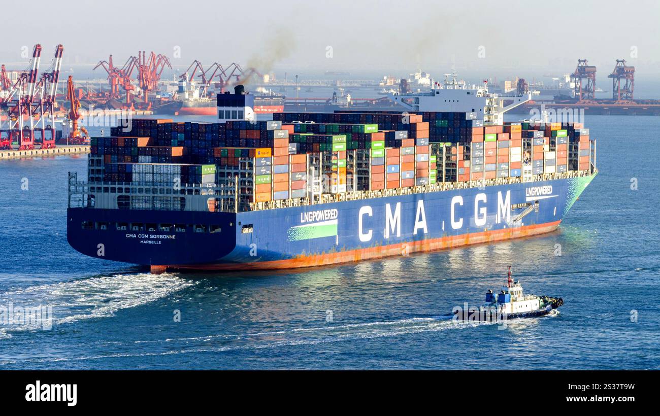 A container ship leaves its berth at the Qianwan Container terminal of ...