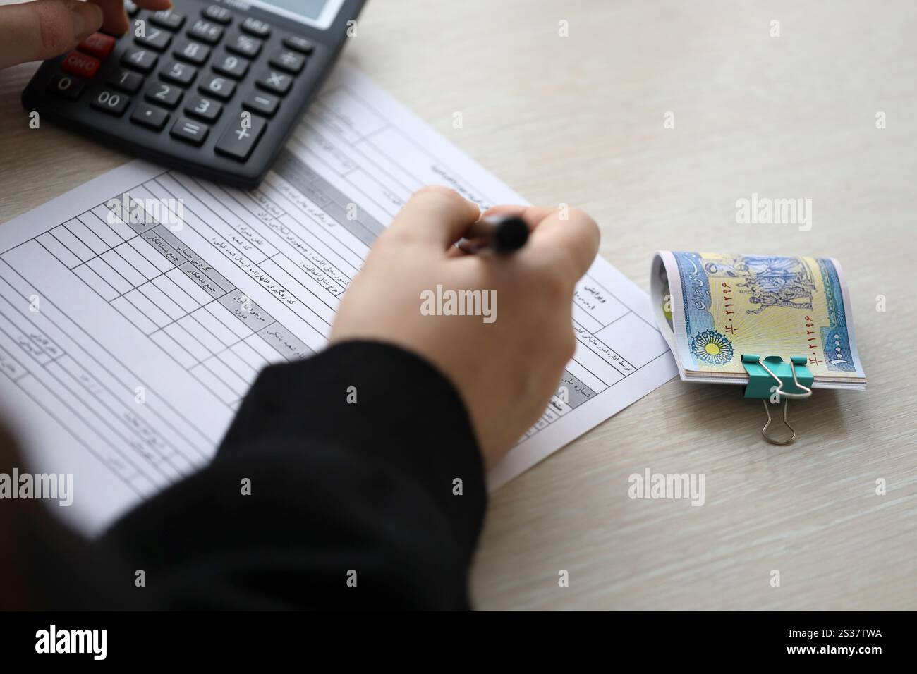 Accountant start to fill Iranian tax form on office table. Taxation ...