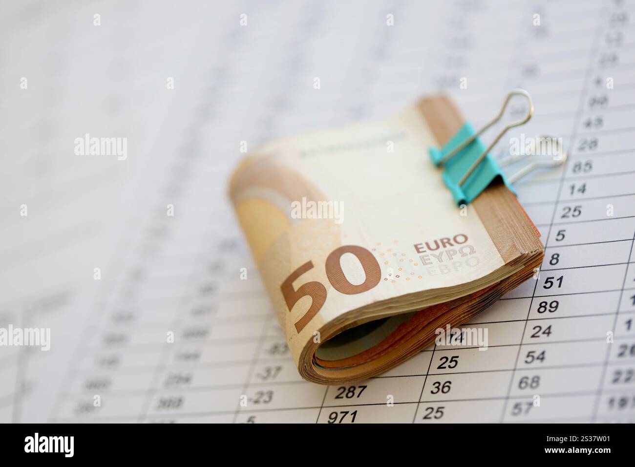 Heap of euro money bills in stationery clip on papers with calculations ...
