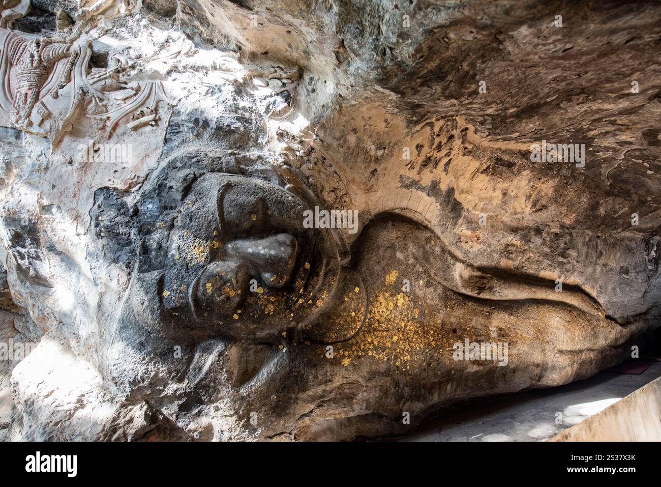 a stone carving reclining Buddha figure in the Fa Tho Cave at Tham Khao ...