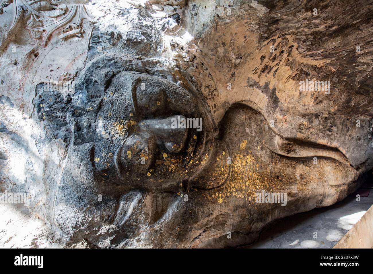 a stone carving reclining Buddha figure in the Fa Tho Cave at Tham Khao ...