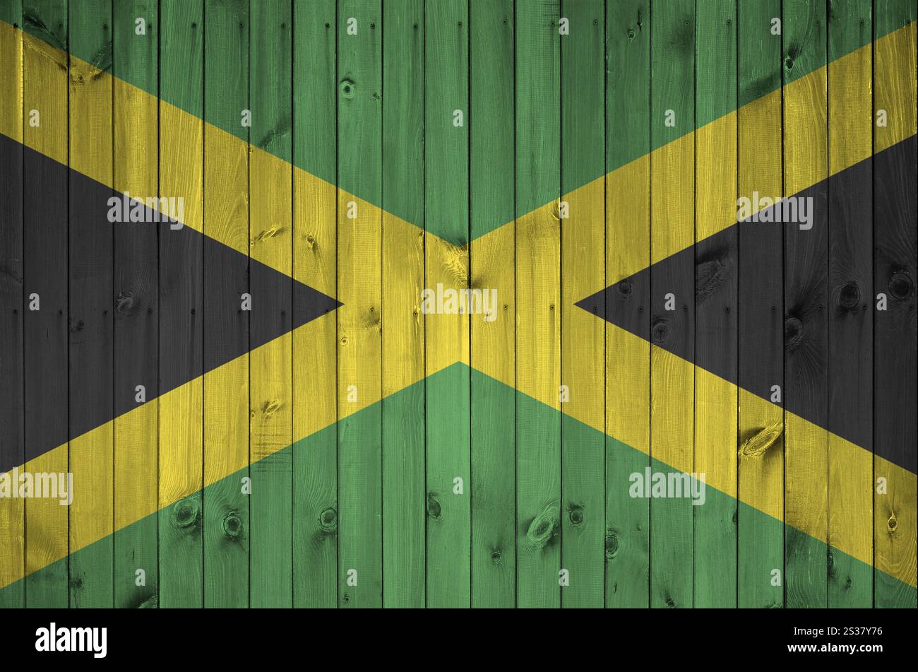 Jamaica flag depicted in bright paint colors on old wooden wall close ...