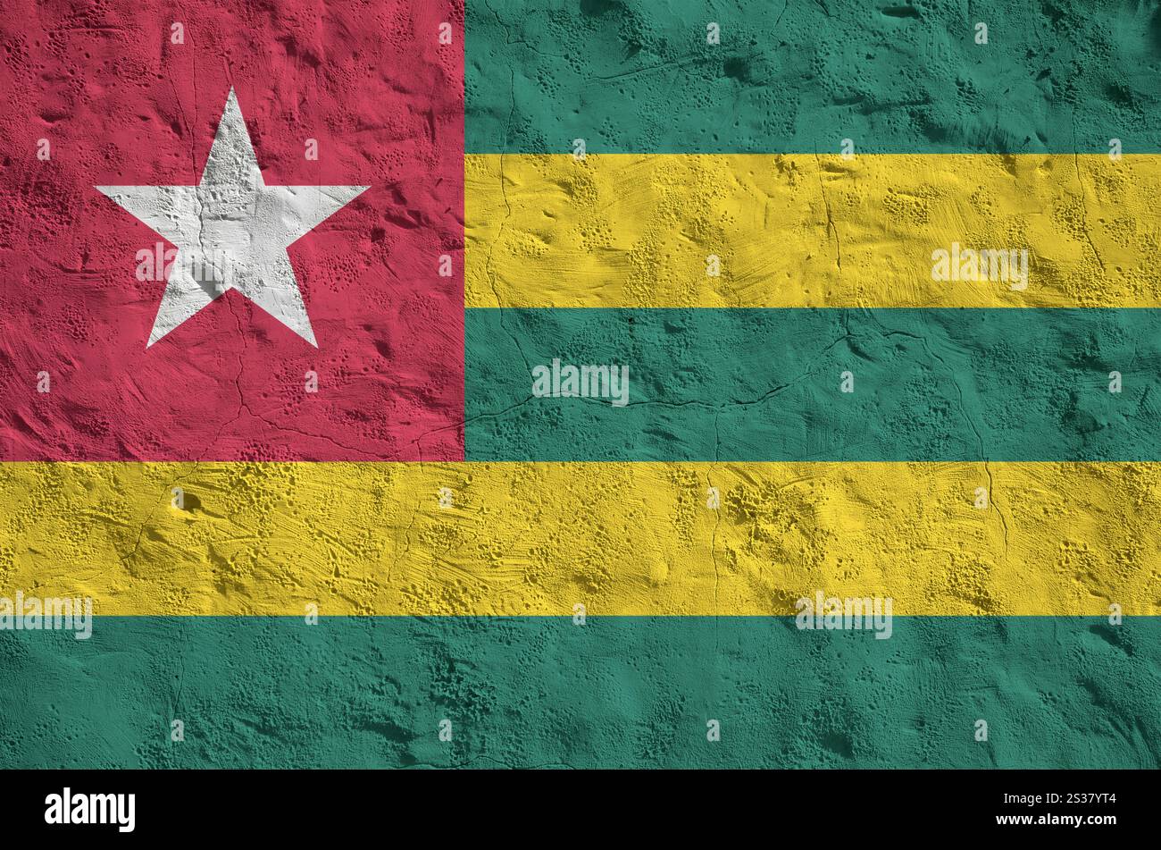 Togo flag depicted in bright paint colors on old relief plastering wall ...