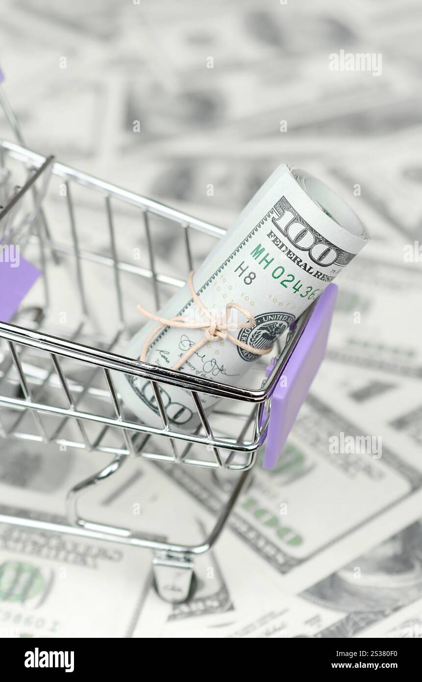 Small shopping trolley with dollars banknotes. Big amount of US dollar ...