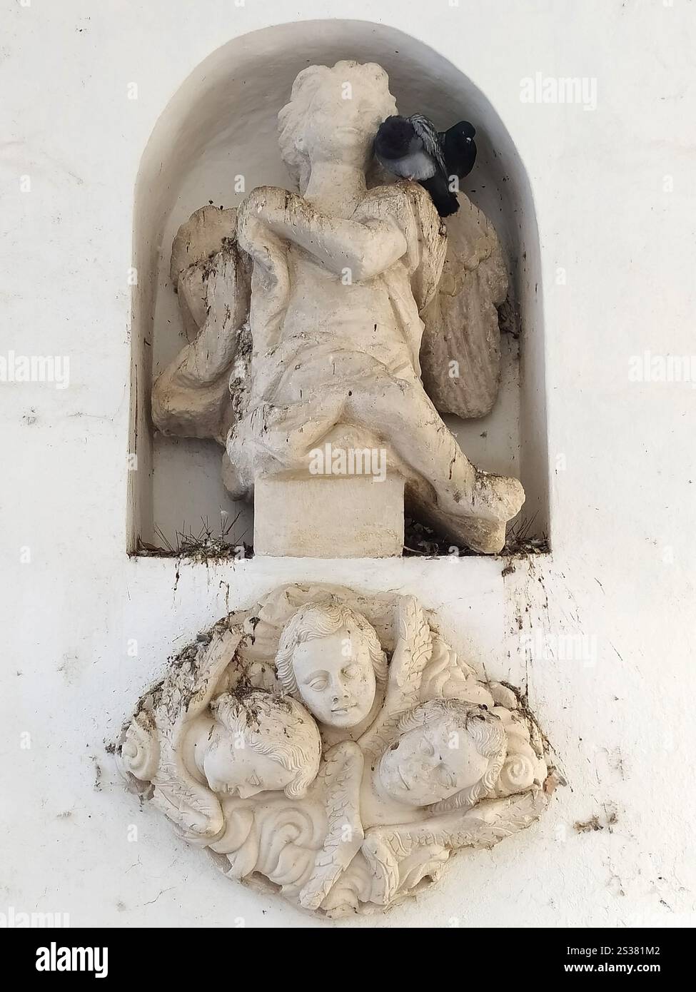 Antique statues on the wall in the form of children angels. Antique ...