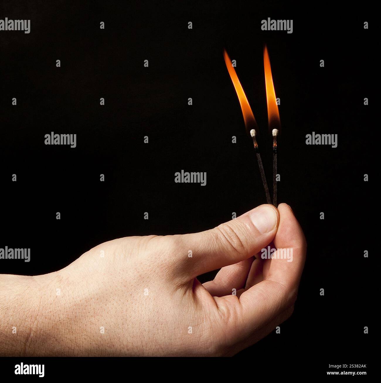 Hand holding burning match sticks on black. Hand holding burning match ...