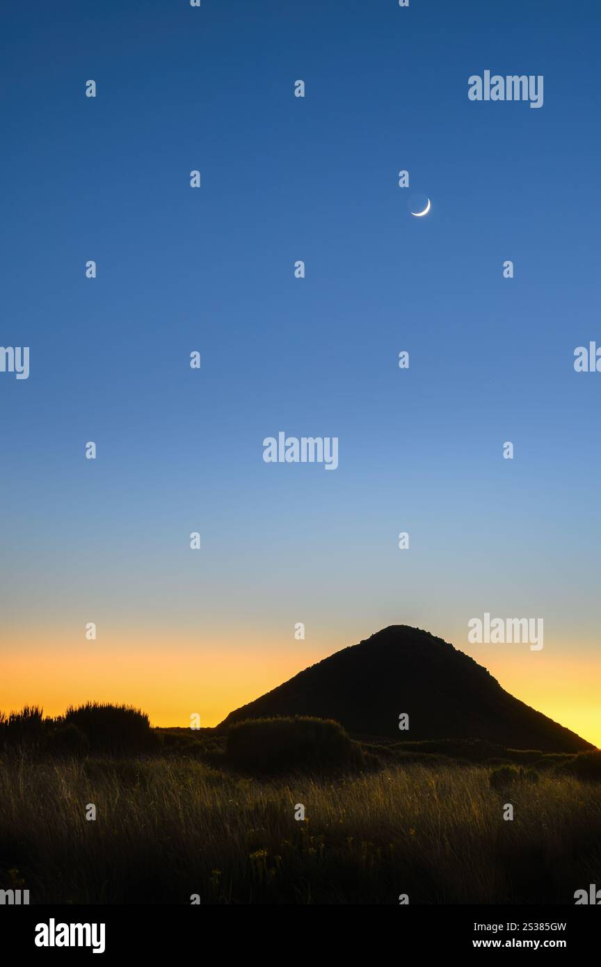 Waning crescent moon above the mountain ranges at sunrise. Taranaki ...