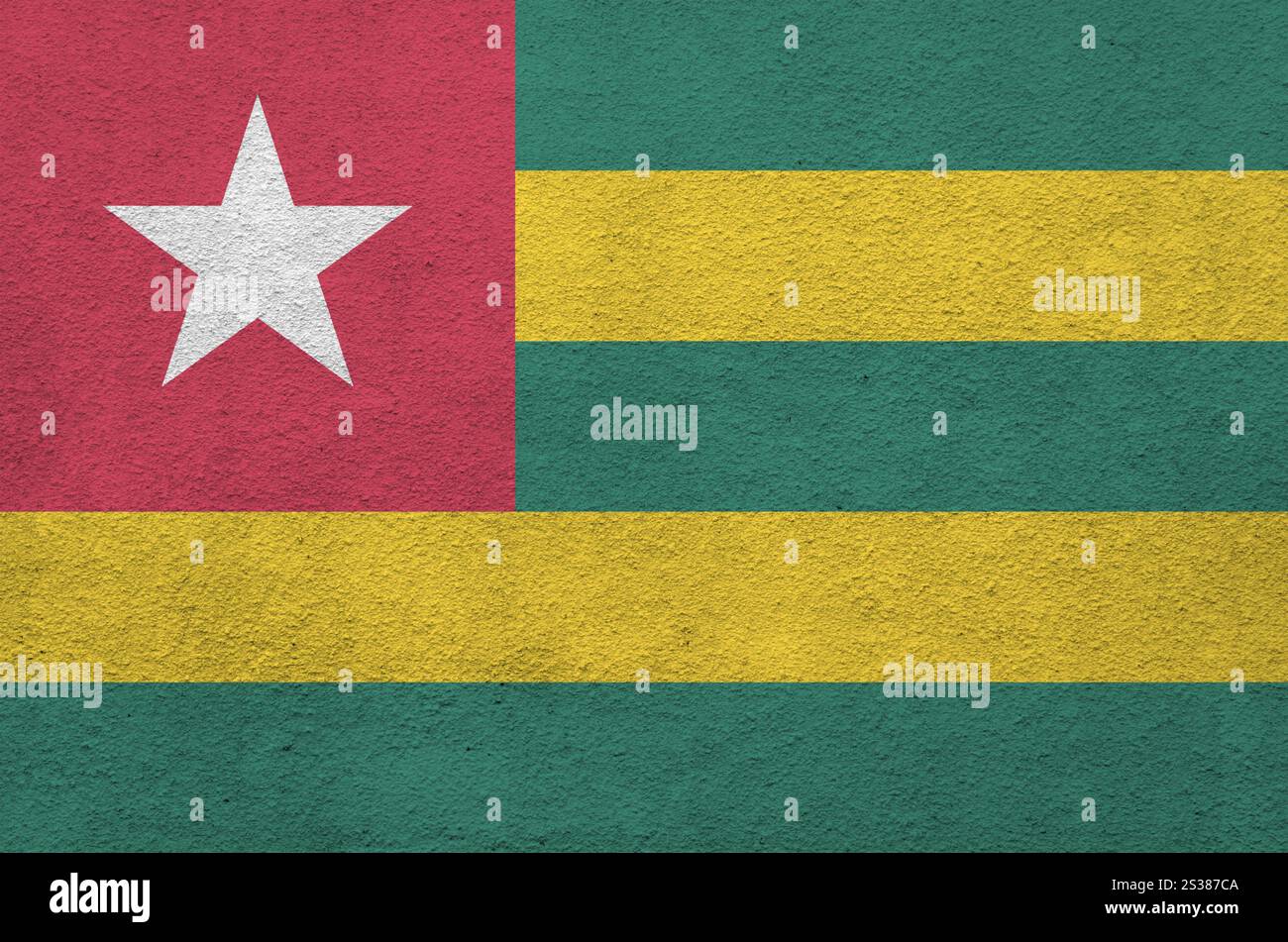 Togo flag depicted in bright paint colors on old relief plastering wall ...