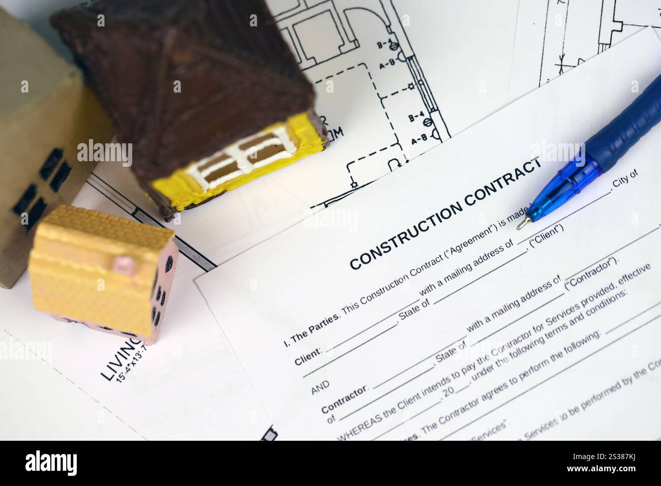 Residential construction agreement ready to sign with small toy houses ...