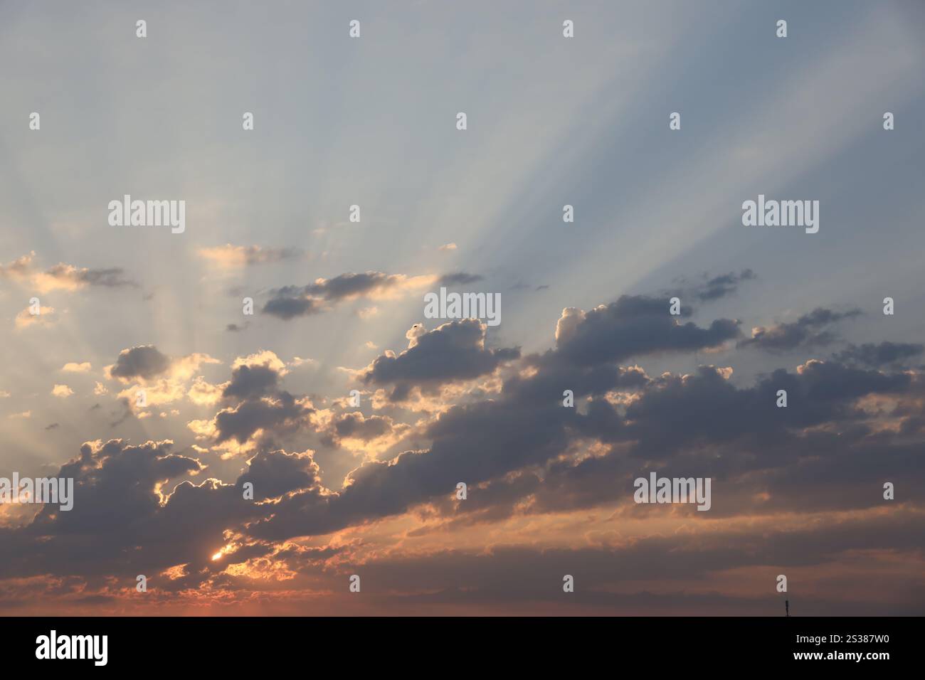 Beautiful sunrise with warm orange sunlight and beams through cloudy ...