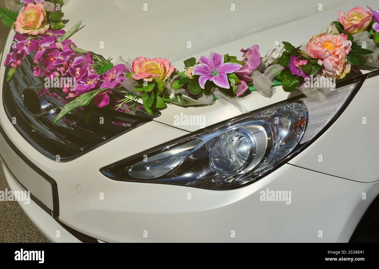 A detailed photo of the hood of the wedding car, decorated with many ...