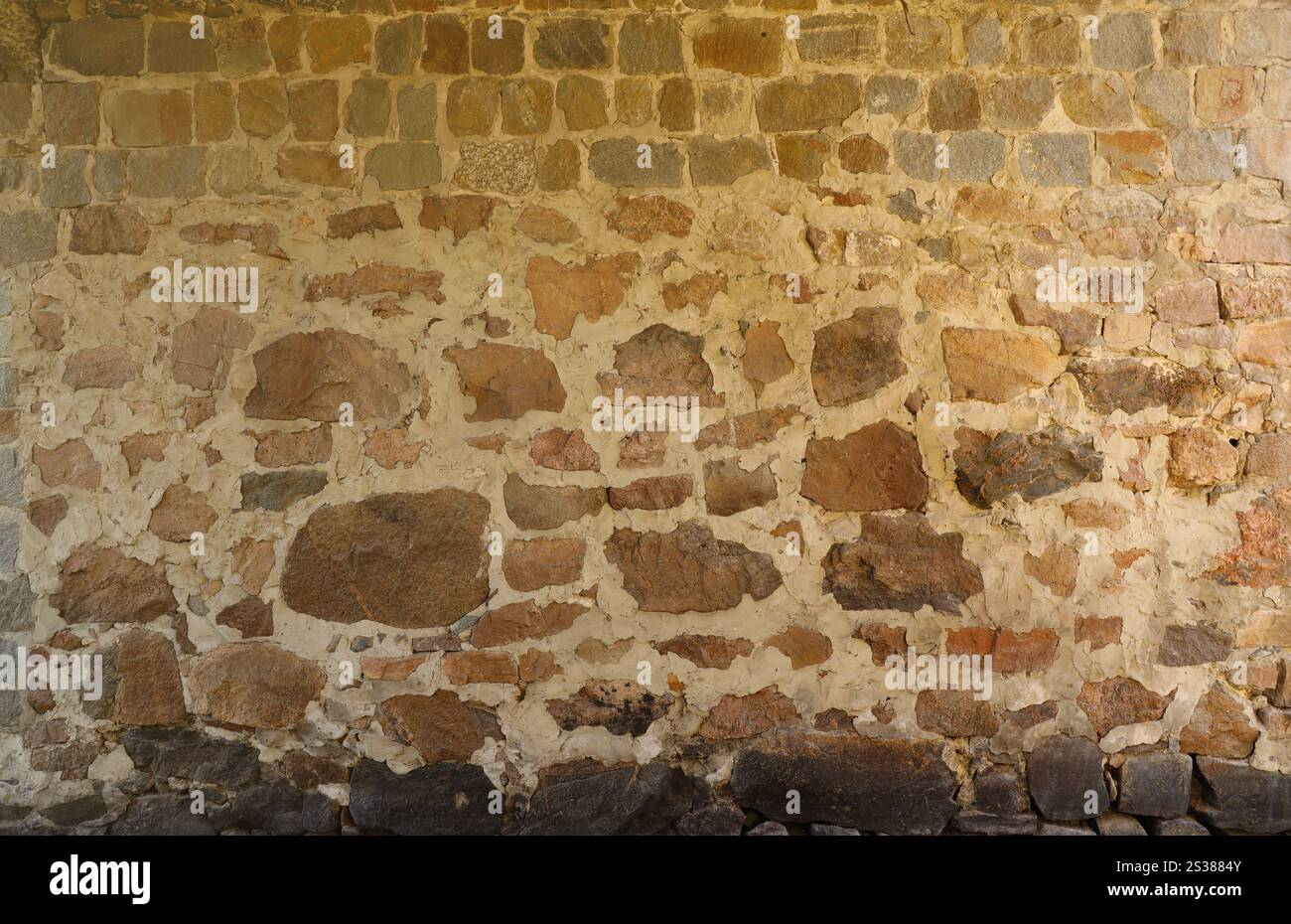 Texture of a stone wall with many big brown and grey stones armed with ...