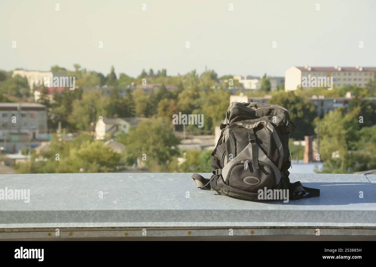 Black backpack lies on metal border of residental multistorey building ...