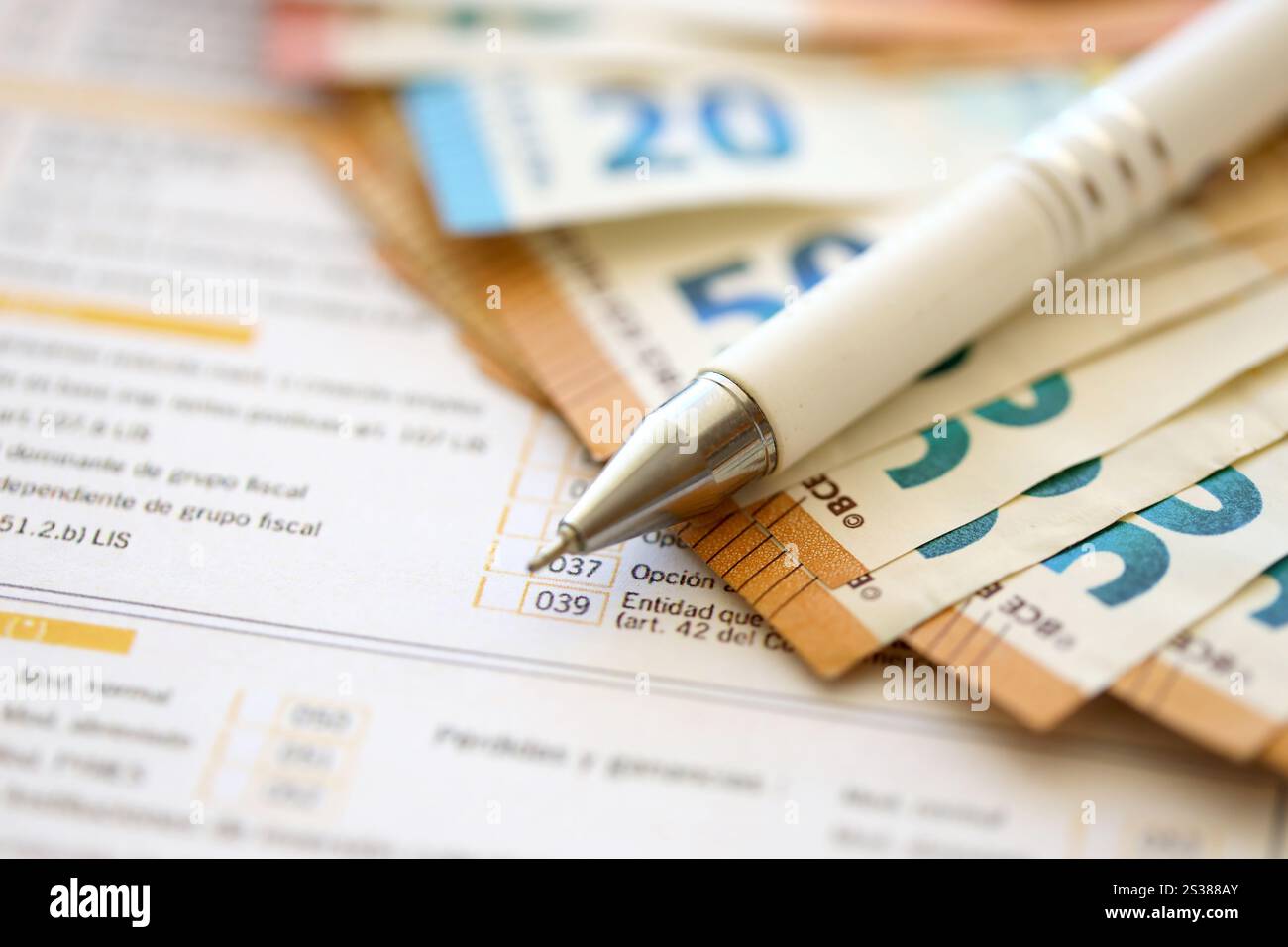 Filling italian tax form process with pen and euro money bills close up ...