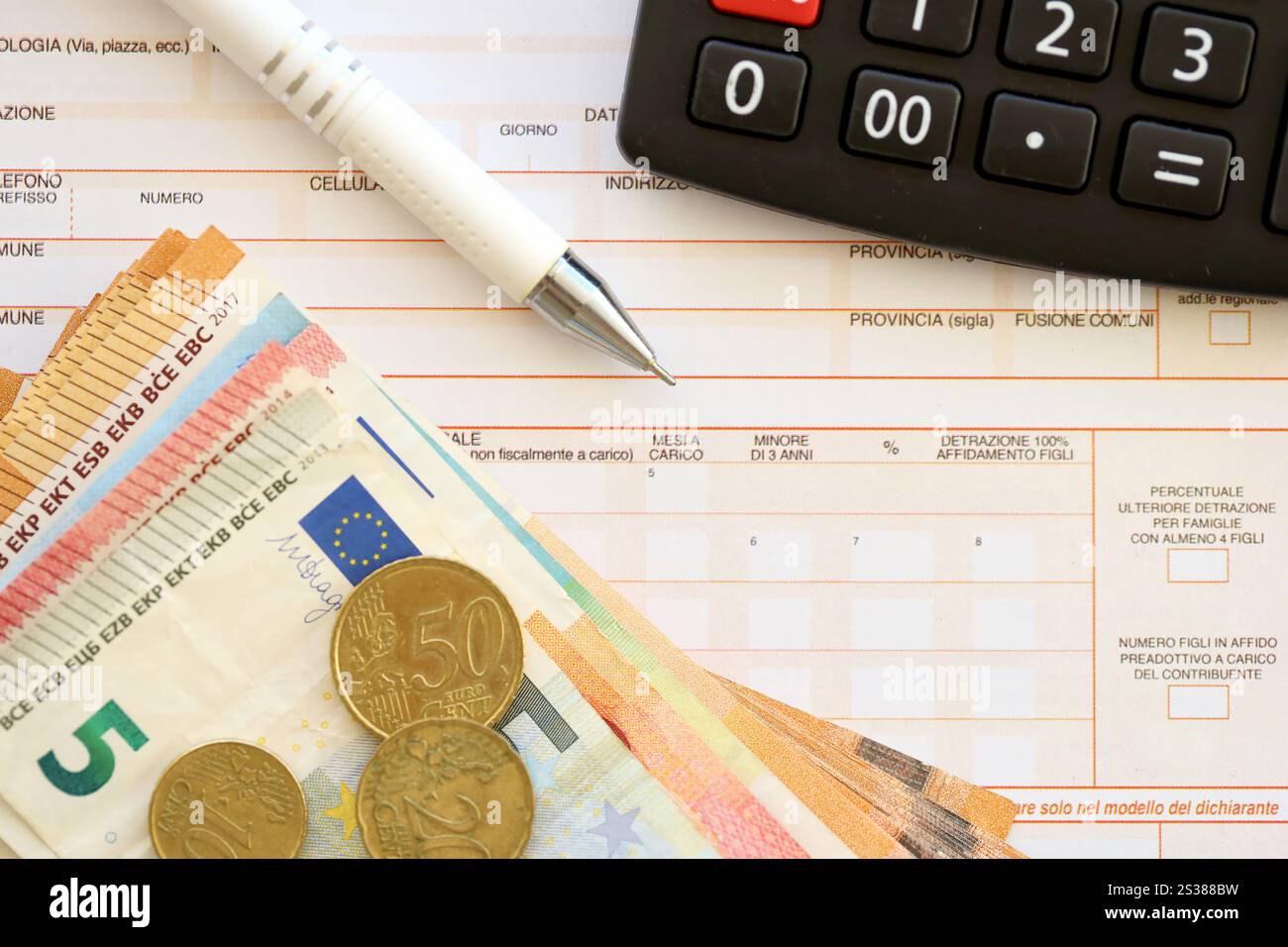 Filling italian tax form process with pen, calculator and euro money ...