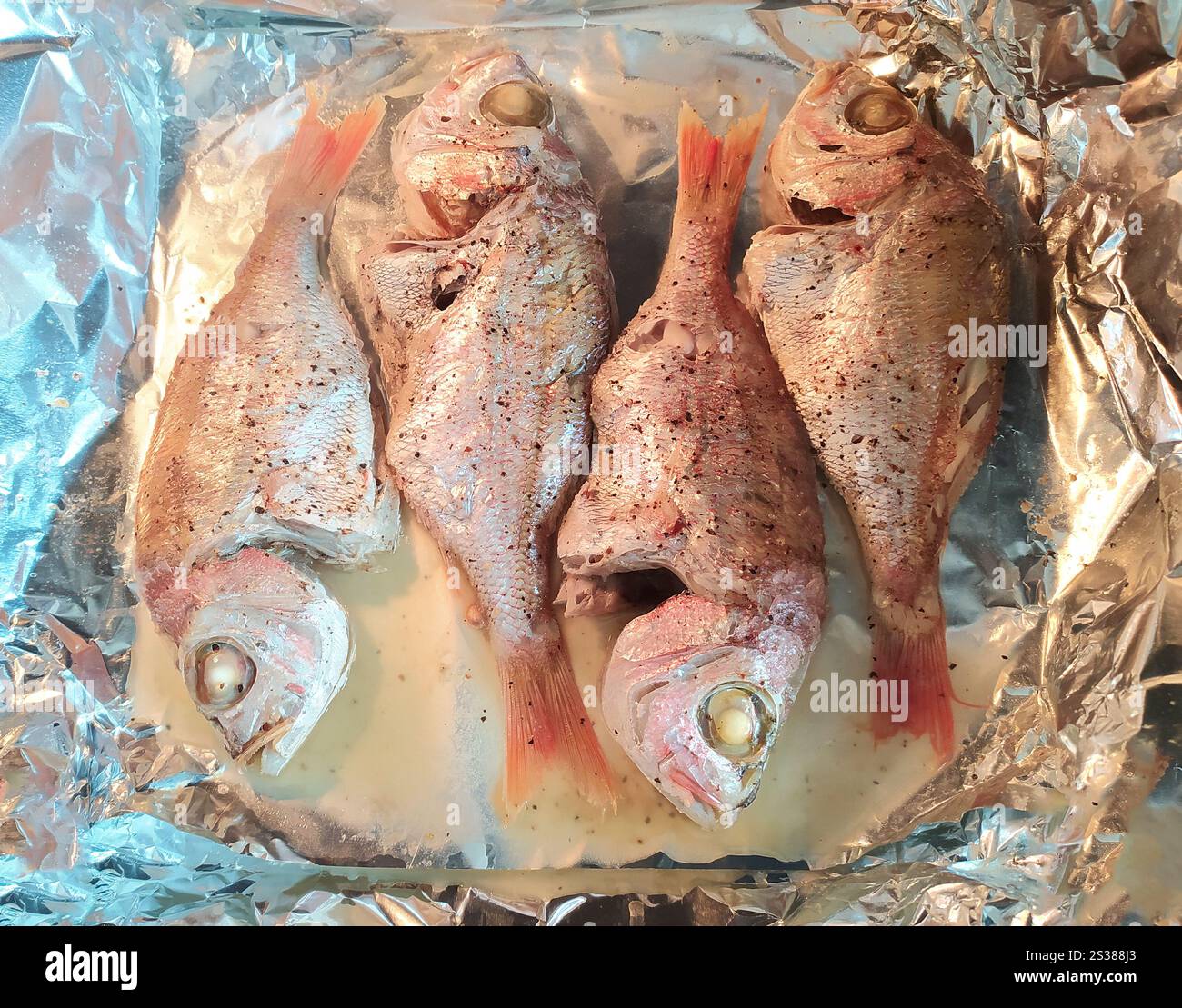 Cooking fresh fish on foil. Top view and close up. Healthy sea food ...