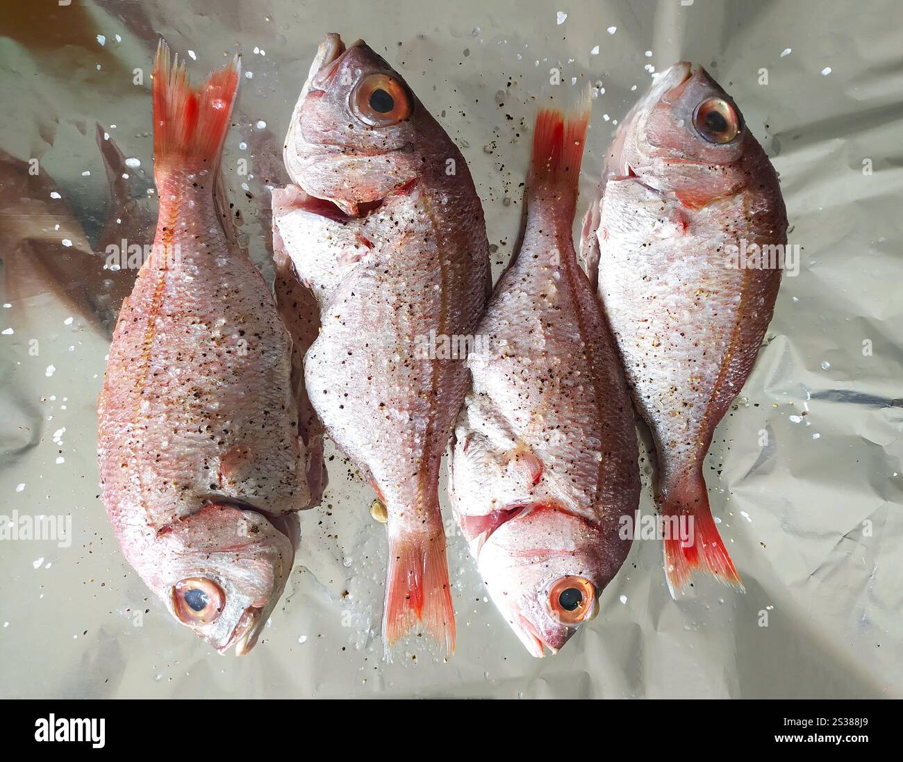 Cooking fresh fish on foil. Top view and close up. Healthy sea food ...