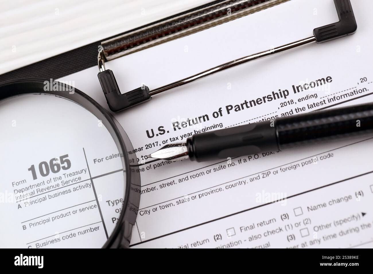 IRS Form 1065 US Return of Partnership Income blank on A4 tablet lies on office table with pen ...