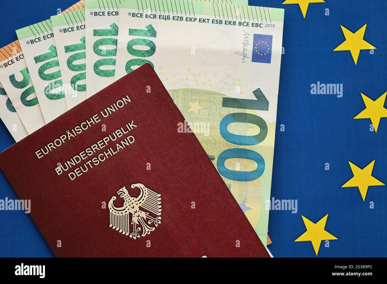 Red German passport of European Union and money on blue flag background ...