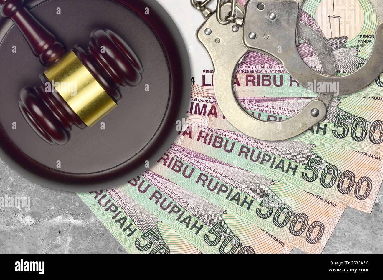 5000 Indonesian rupiah bills and judge hammer with police handcuffs on ...