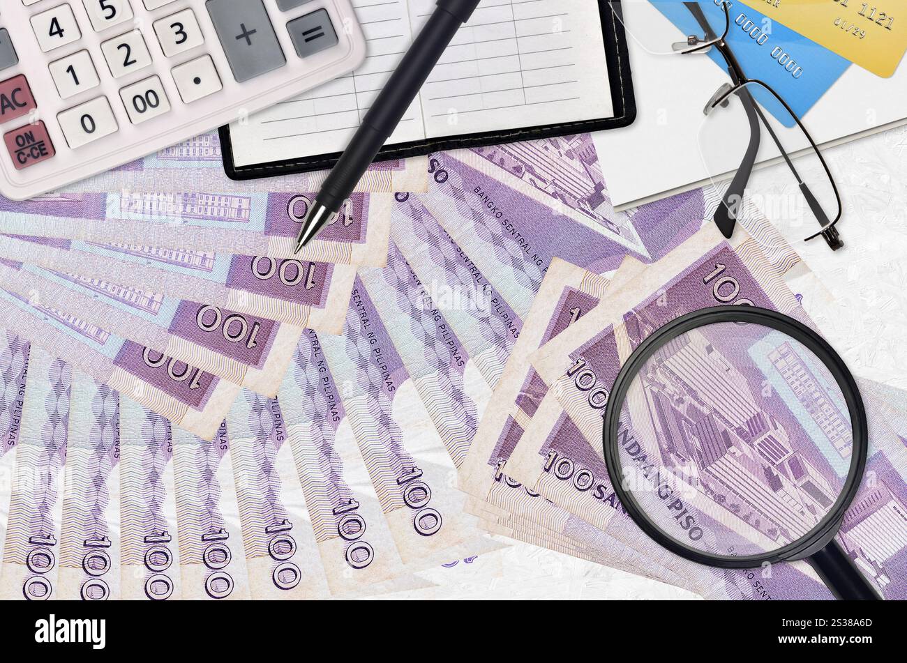 100 Philippine piso bills and calculator with glasses and pen. Tax ...