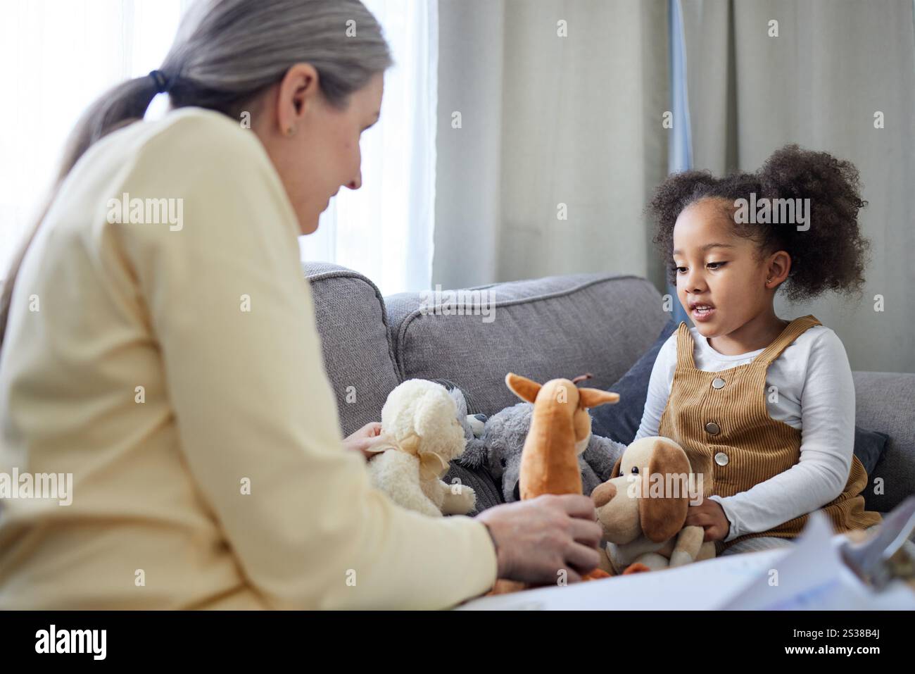 Psychologist, kid and teddy bear in office for therapy, ADHD assessment ...