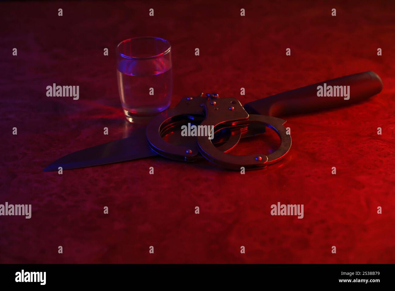 Glass with vodka alcohol drink, knife and handcuffs. Concept of ...