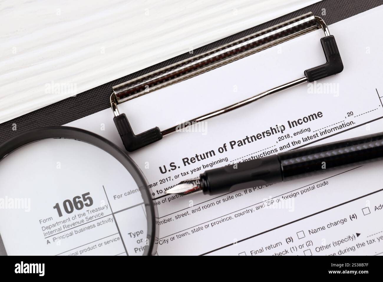 IRS Form 1065 US Return of Partnership Income blank on A4 tablet lies on office table with pen ...