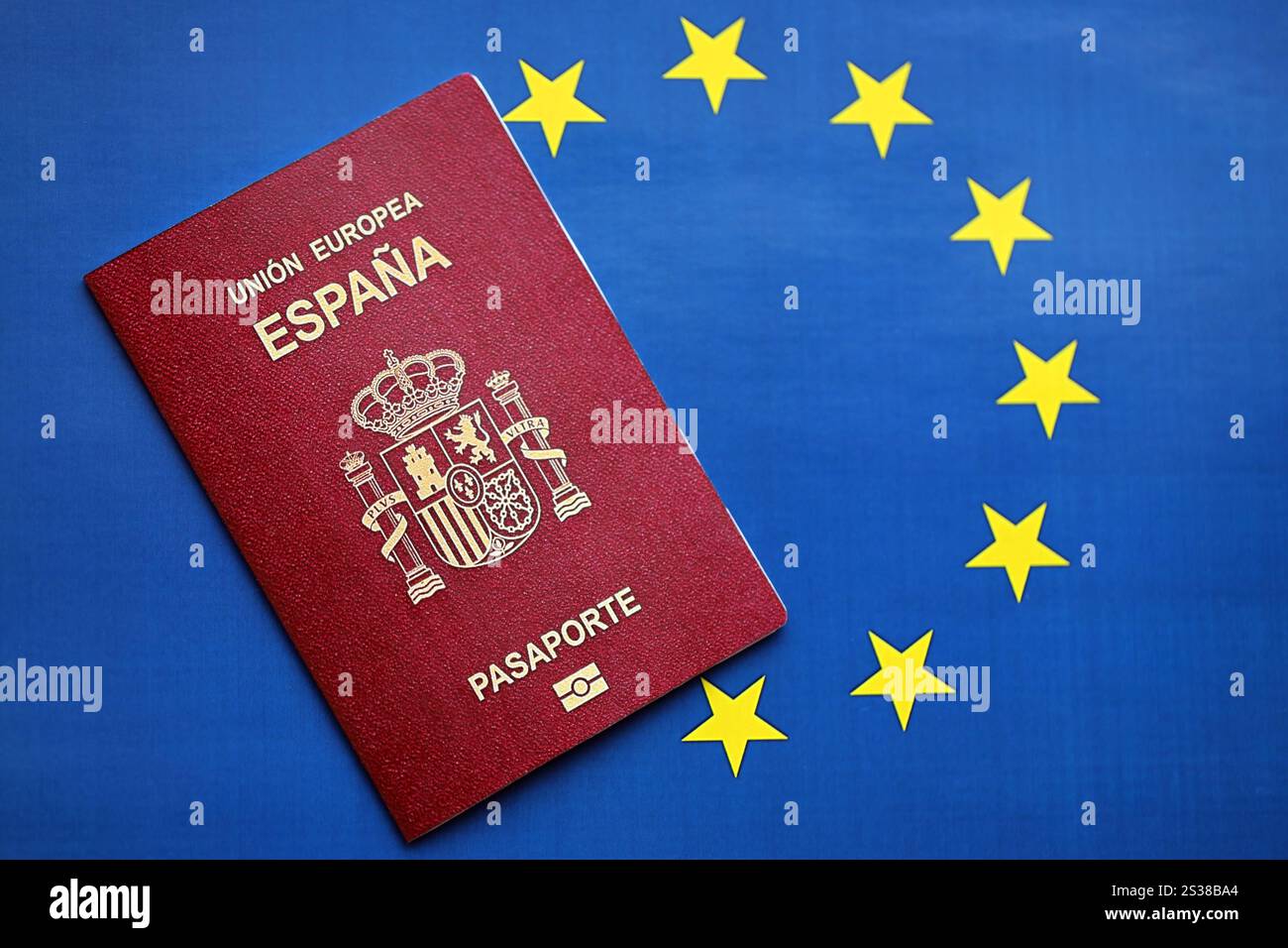 Red Spanish passport of European Union on blue flag background close up ...
