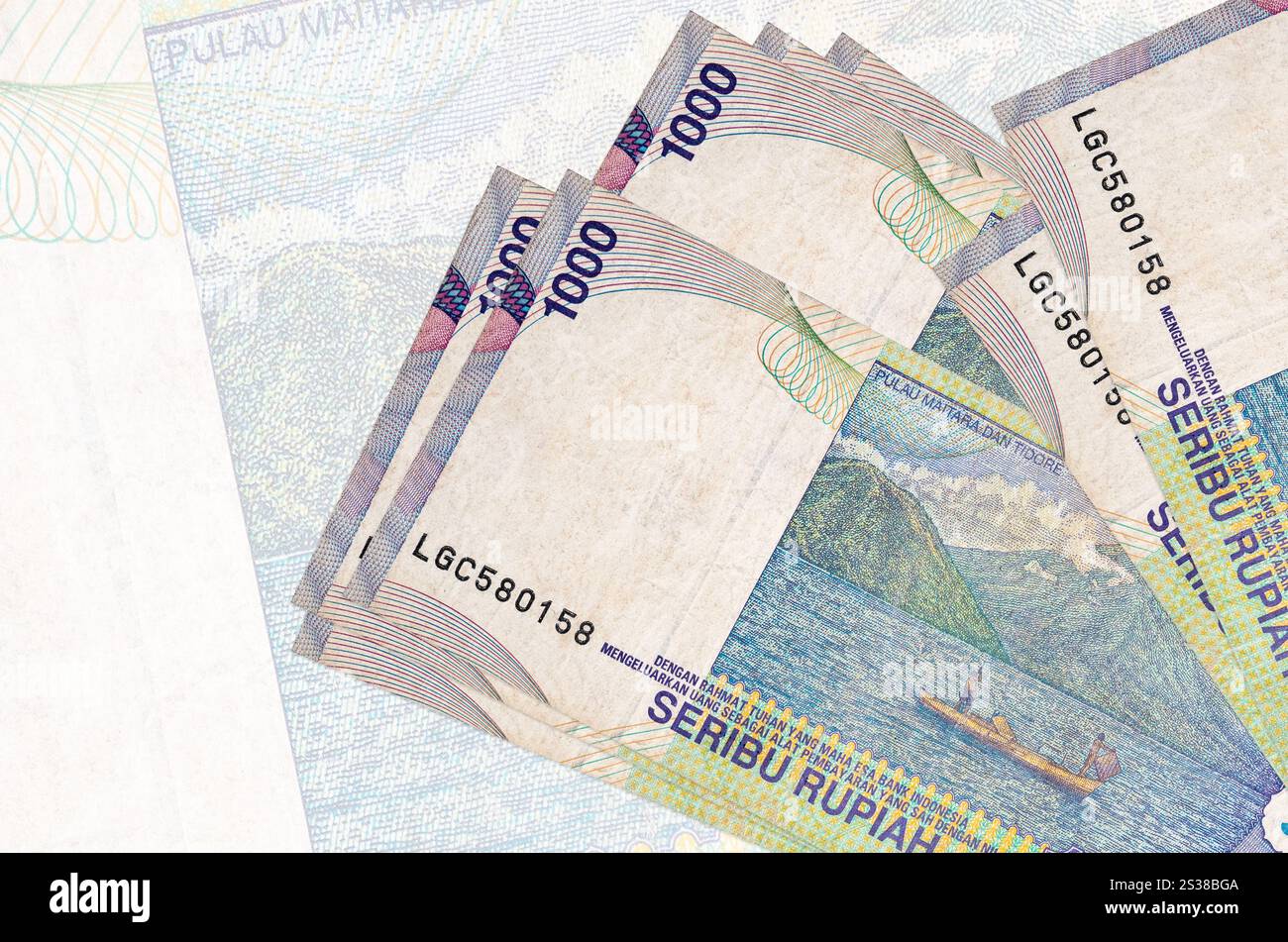 1000 Indonesian rupiah bills lies in stack on background of big semi ...