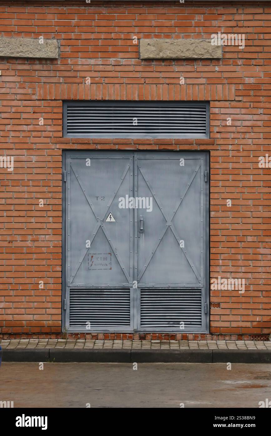 Old metallic grey door with licked paint and attention high voltage ...