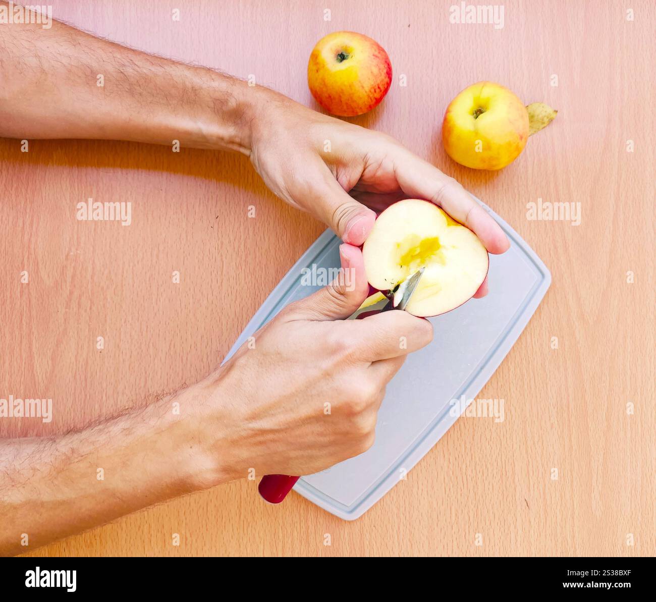 Close up male hands cut an apple into slices. Top view of preparing ...
