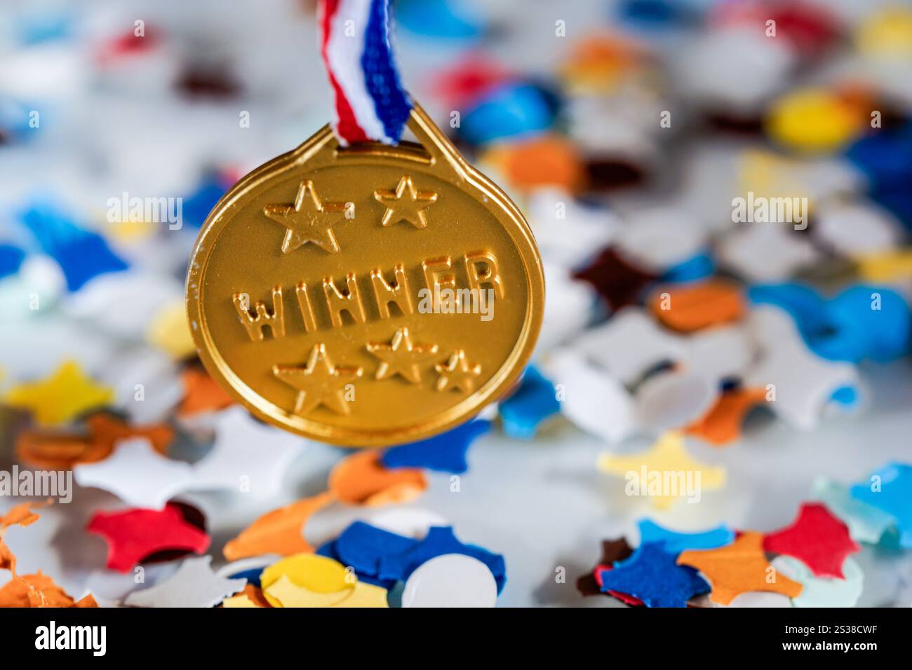 Winner symbol photo of a gold medal with winner inscription on confetti ...